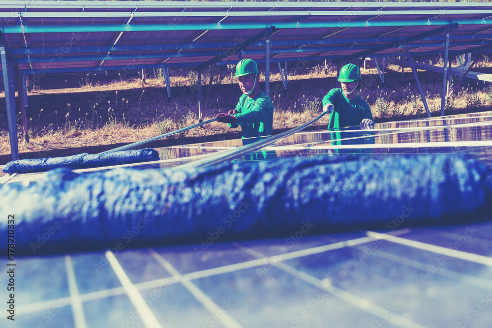 Foto de labor working on cleaning solar panel at solar power plant ...