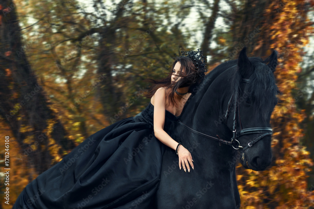 girl black queen witch in black dress and tiara riding horseback on a ...