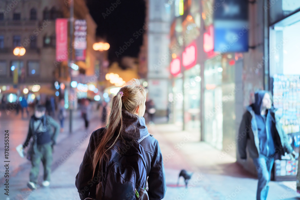 Back view of girl walking on city street at night, Prague Stock Photo ...