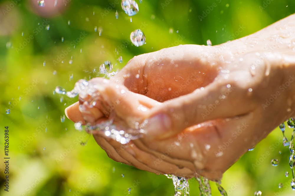 Woman washing hand outdoors. Natural drinking water in the palm. Young ...