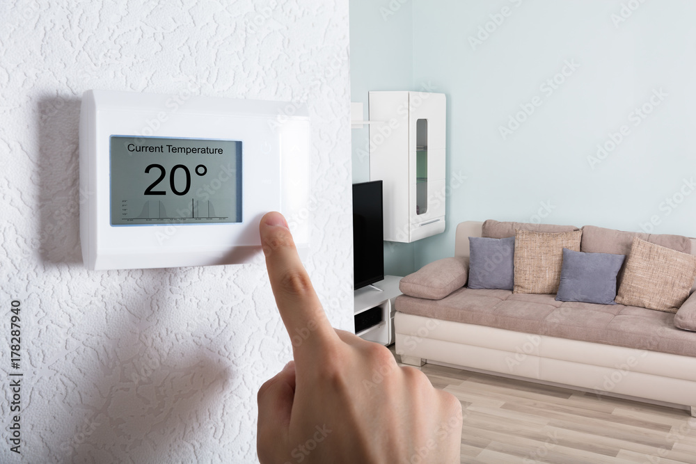 Person's Hand Adjusting Digital Thermostat Stock Photo | Adobe Stock