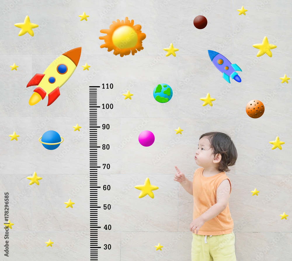 Closeup happy asian kid stand and point to scale of measure height with ...