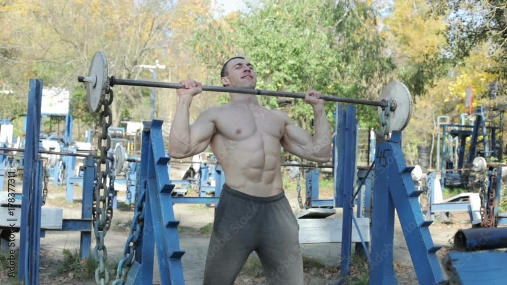 Bodybuilder lifts the bar by training his muscles, he works on the ...