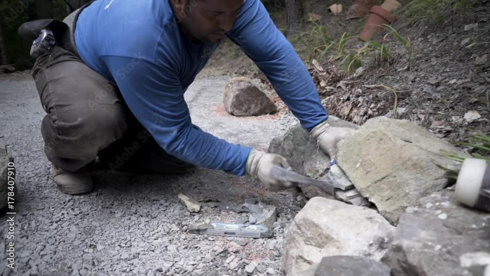 Hardscape uses a rock shim to check and change the level of a large ...