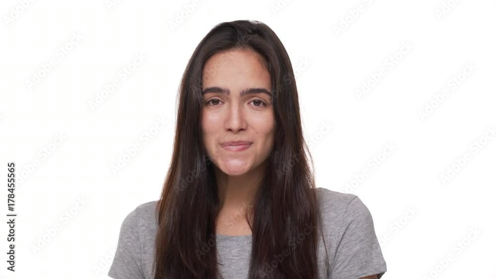 portrait of shy caucasian woman with pursed lips smiling at camera ...