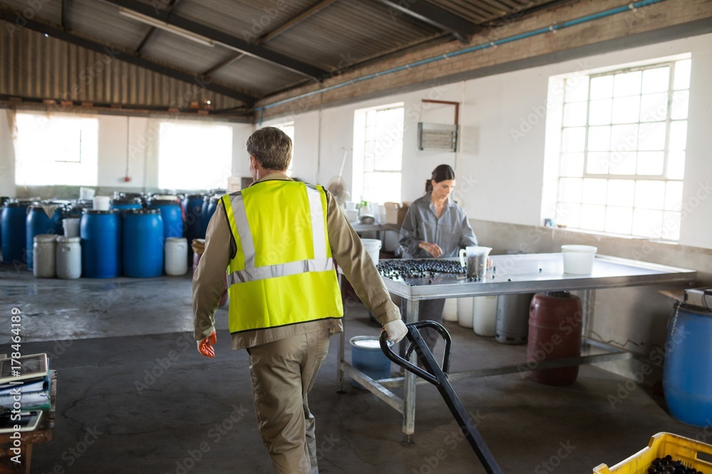 Worker pulling a trolley with crate Stock Photo | Adobe Stock