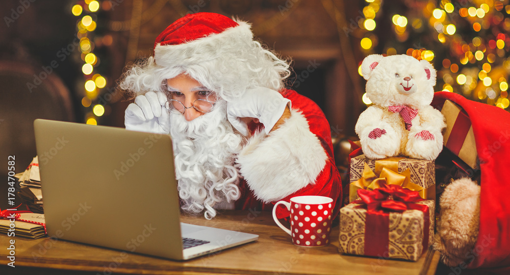 Santa Claus with computer before christmas Stock-Foto | Adobe Stock