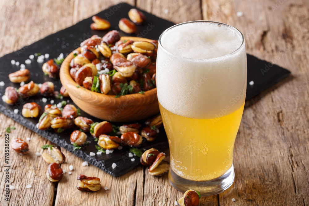 glass of light beer with appetizer from crispy fried salted broad beans ...