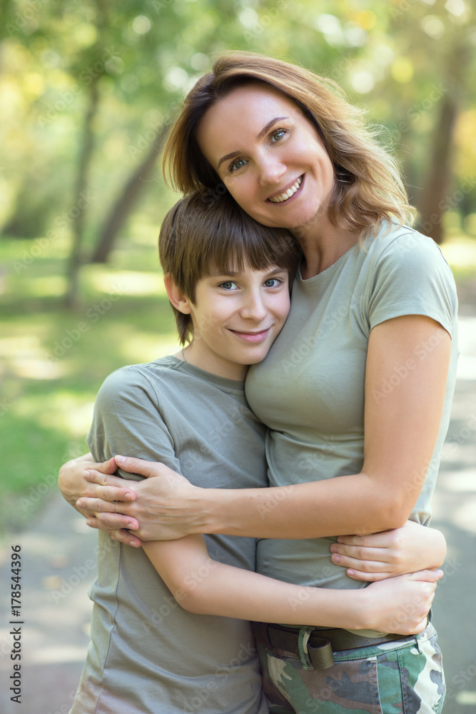 Happy mother and her 11 years old lovely son is embracing outdoor and ...
