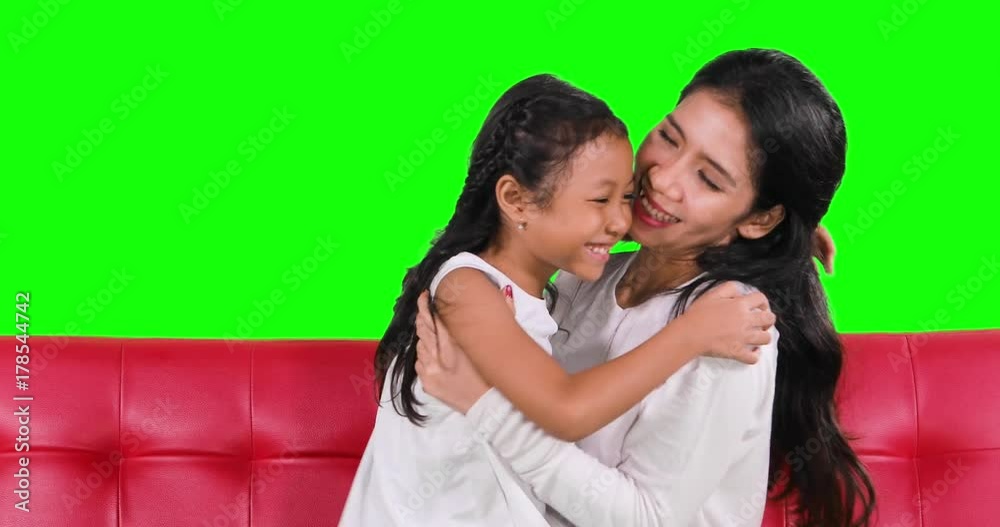 Happy Asian mother hugging her toothless daughter while sitting on the ...