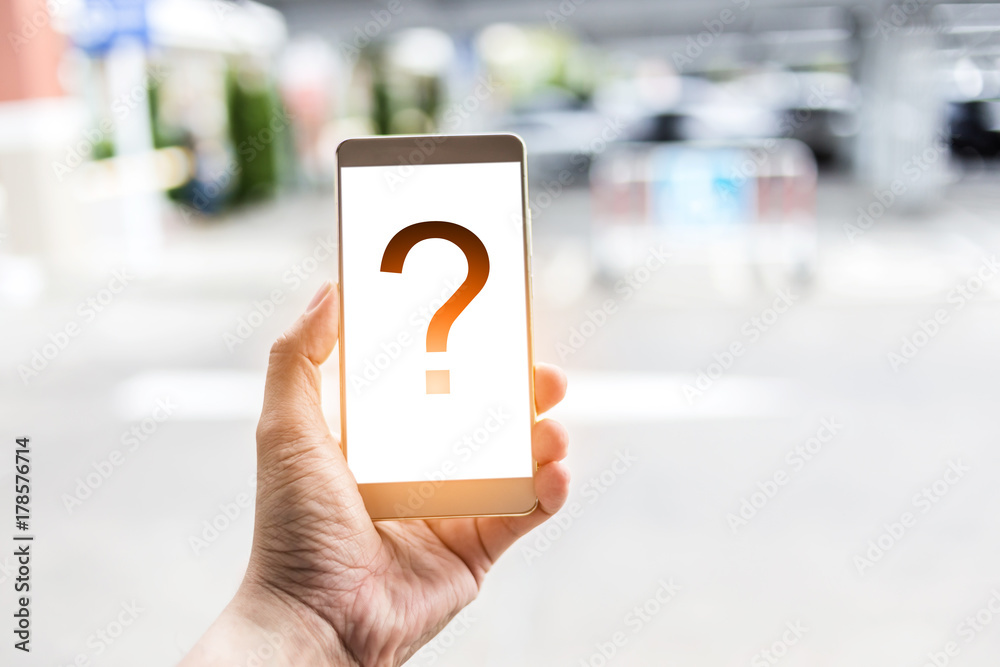 man use smartphone with question mark symbol on screen at carpark ...