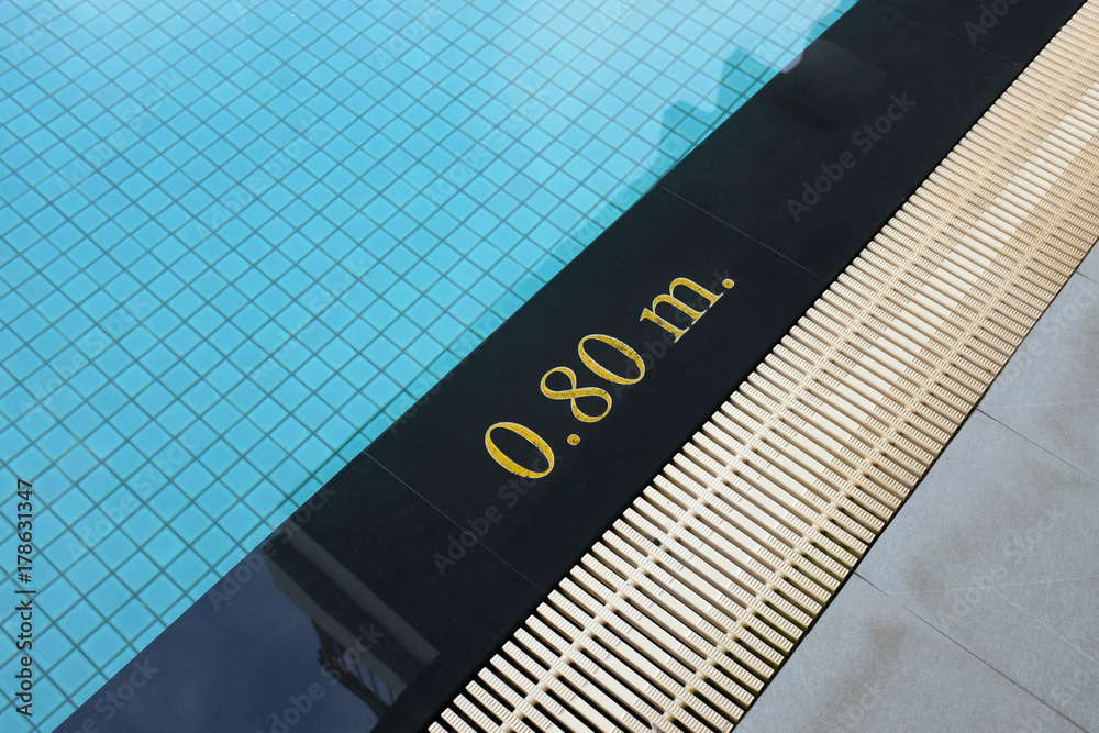 edge of swimming pool and sign indicating the depth of the pool. Stock ...