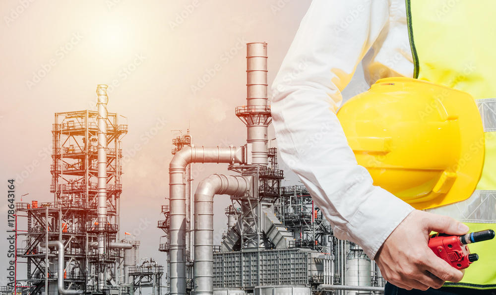 Engineering man standing with white safety helmet against oil refinery ...