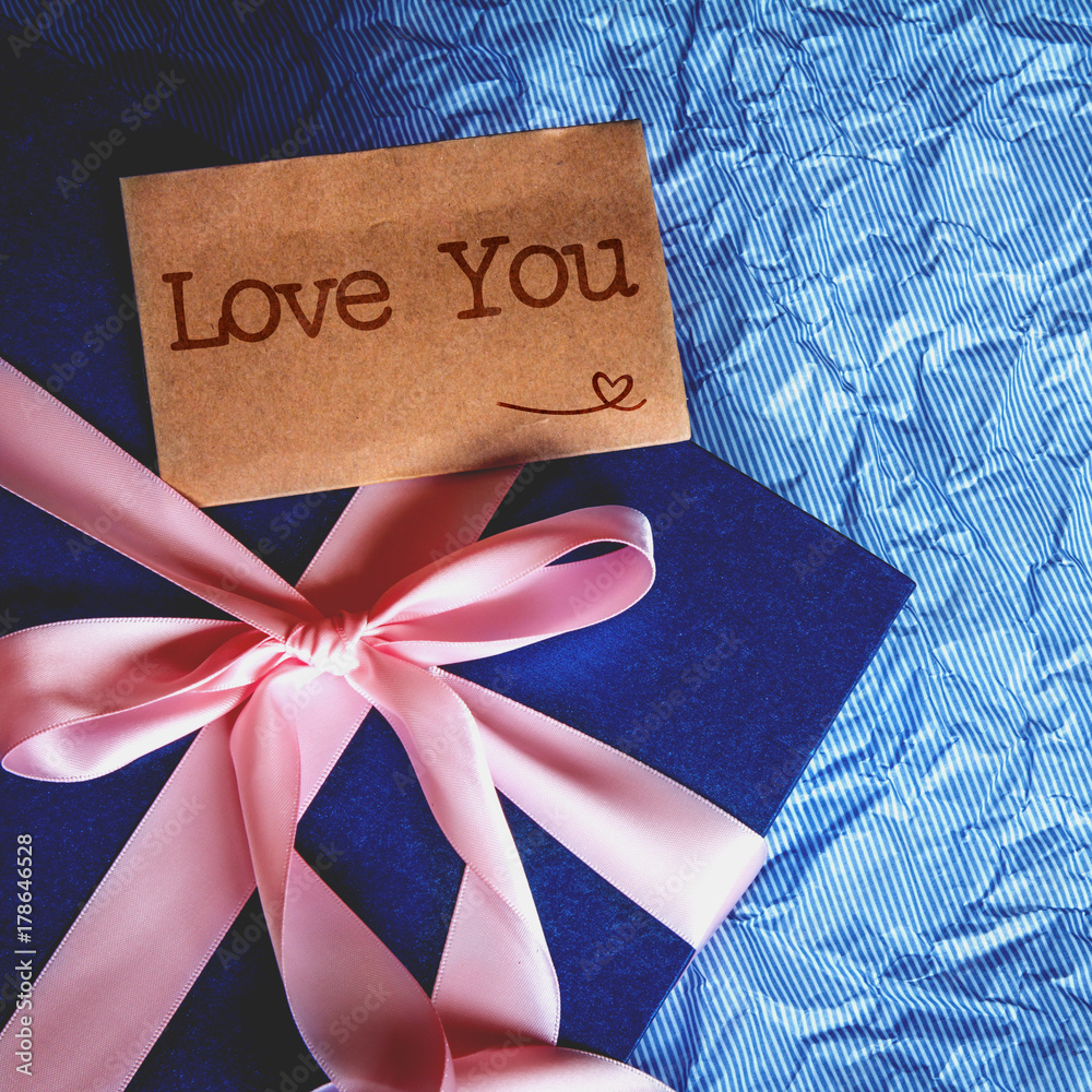 Dark blue gift box with ribbon decoration and Love You text card on ...