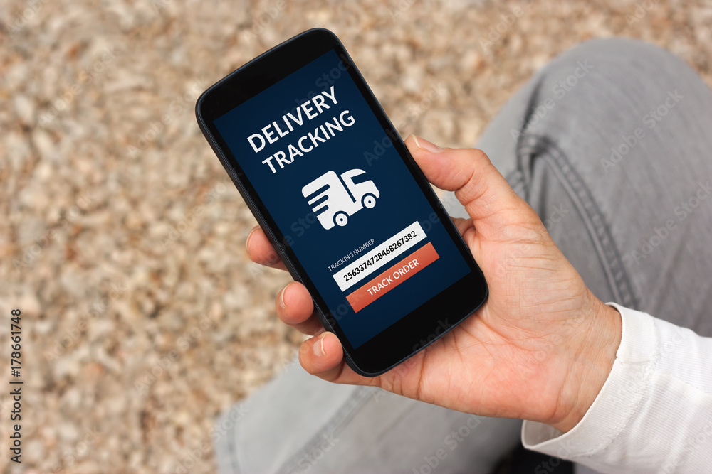 Hand holding smart phone with delivery tracking concept on screen. All ...