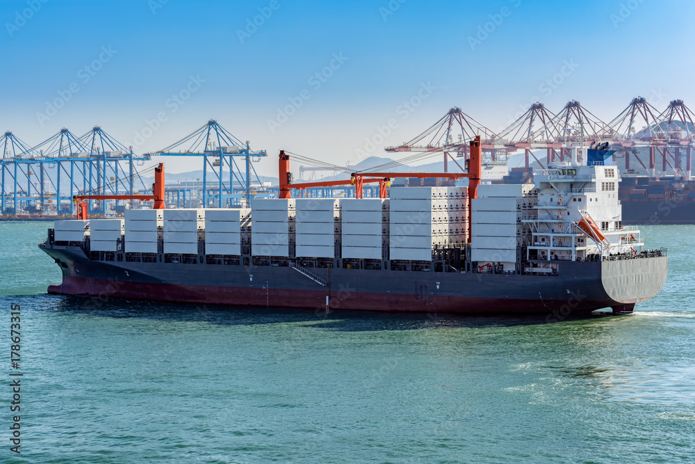 Foto de Container ship leaving a container terminal. do Stock | Adobe Stock