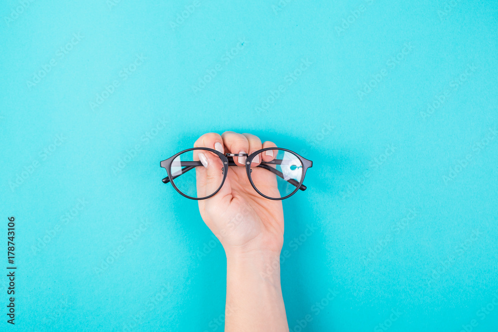 Hands holding glasses on a blue background Stock Photo | Adobe Stock