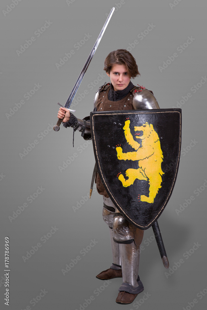 Girl in armor with a sword knight wuth shield over grey background ...