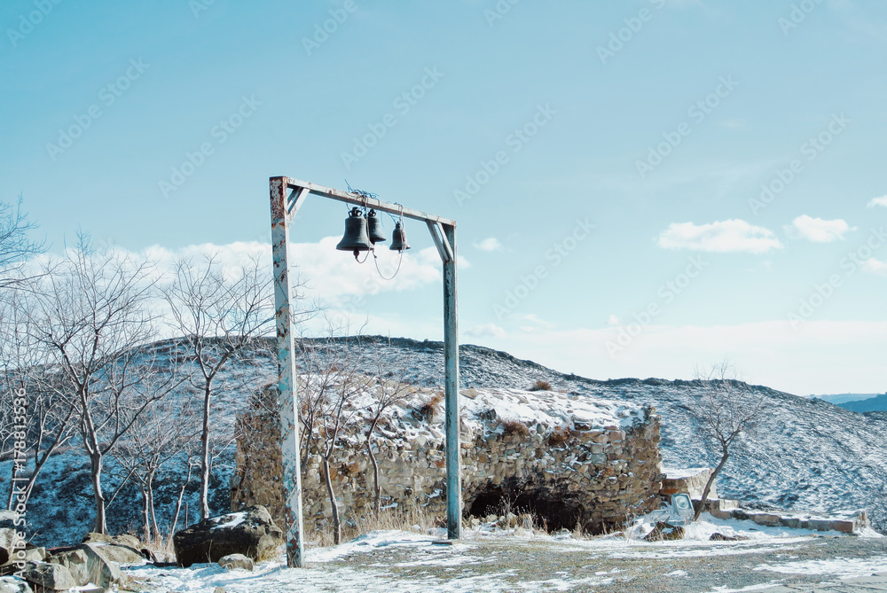 Three bells and the ruins of a brick wall near the Jvari Orthodox ...