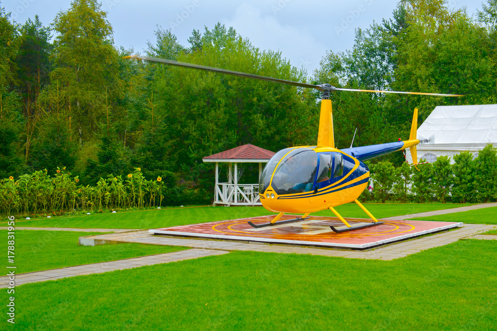Yellow helicopter sits on a heliport - Air transport in the sky. Useful ...