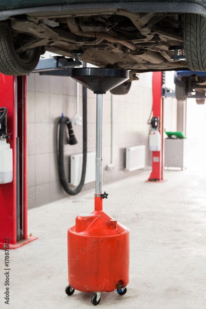 Draining the Oil of a Car in an Oil Drain Tank Stock Photo | Adobe Stock