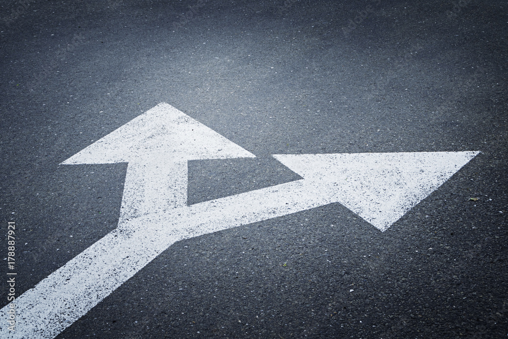 A bi-directional arrow symbol on an asphalt road for the concept of ...
