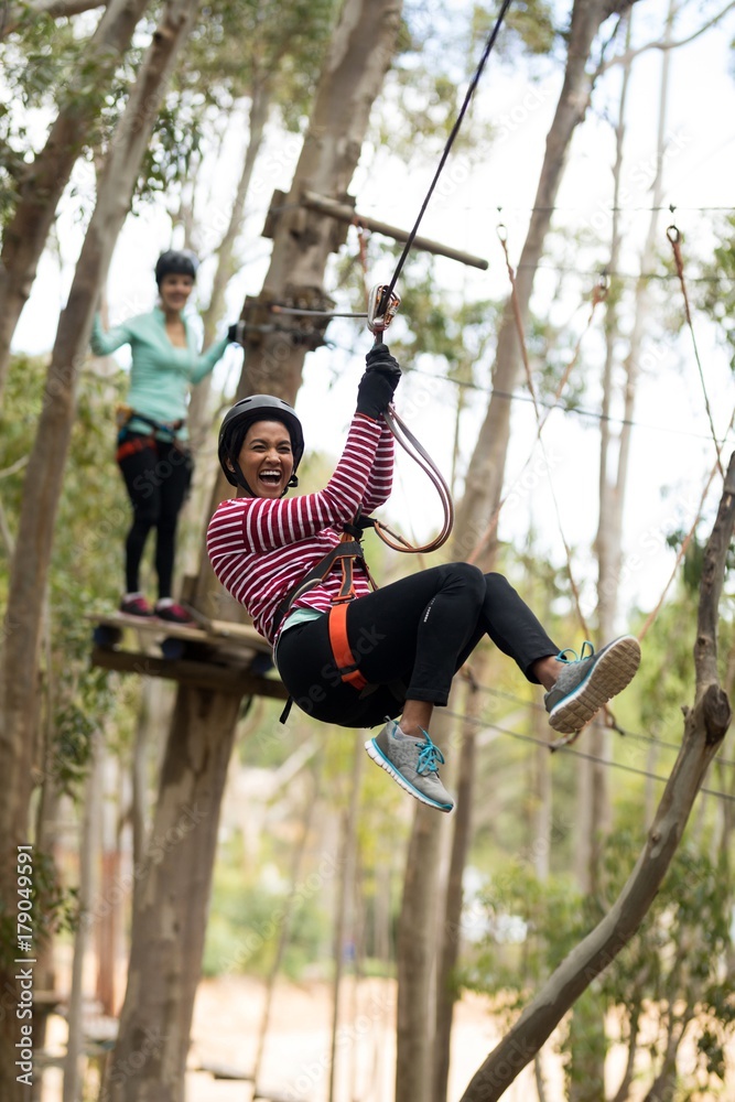 Woman on zipline in adventure park Stock Photo | Adobe Stock