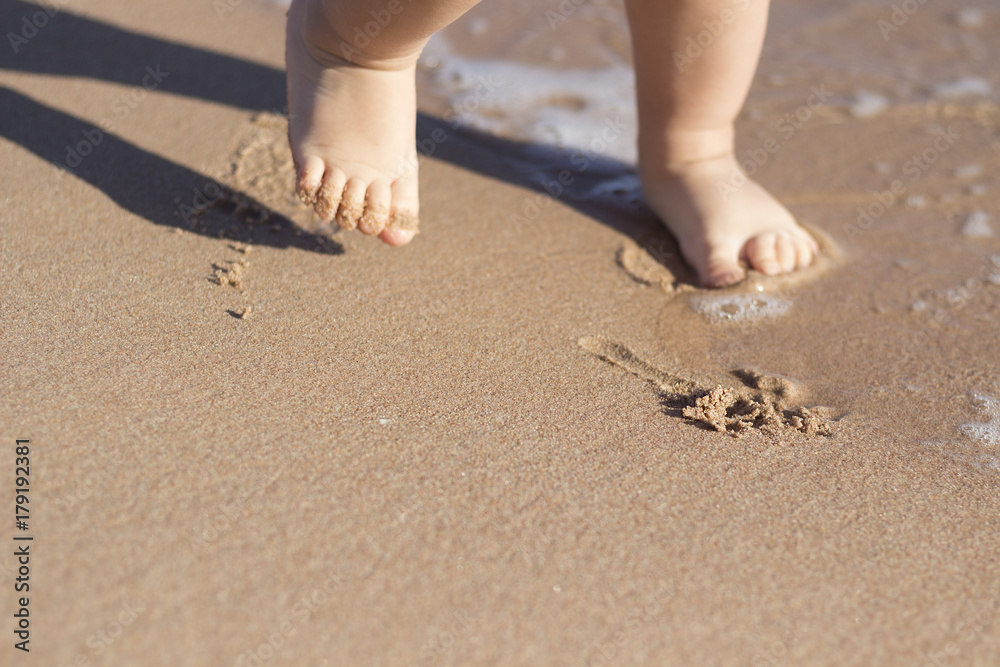 Legs of children stand on the beach. Baby feet in the sand. Summer ...