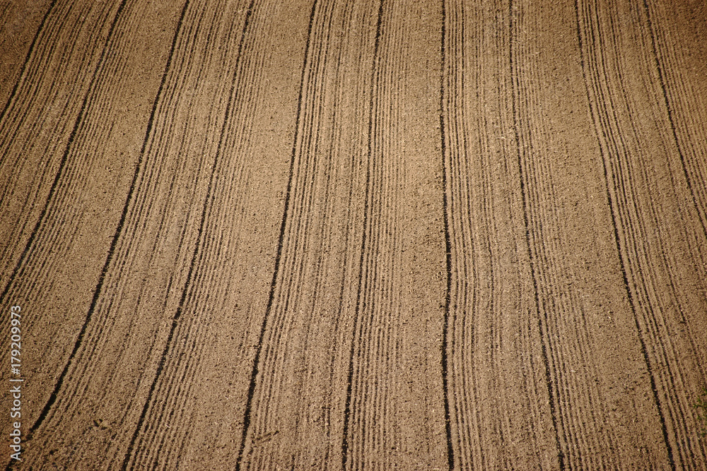 Furchen auf dem Feld / Die durch Traktorreifen hervorgerufenen Spuren ...