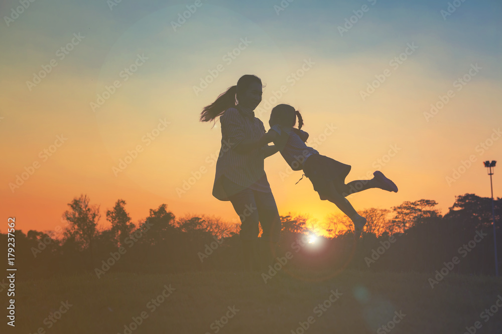 Silhouette of a happy little girl child running into the arms of his ...