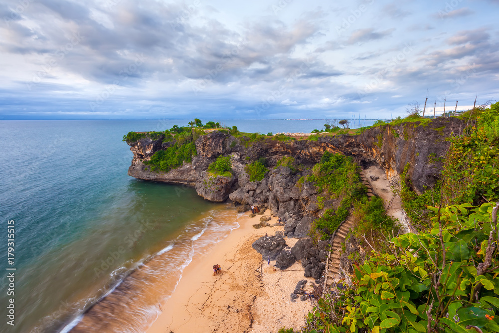 Volcanic green rock with huge stones and stair, on the sea shore ...