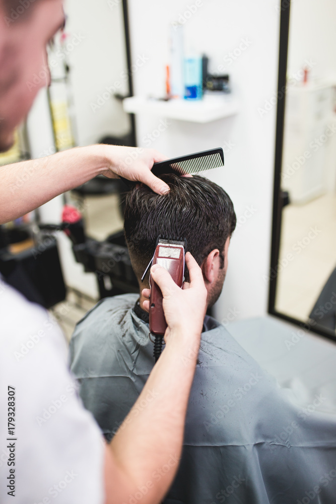 Professional barber doing a haircut to a male client. Stock Photo ...