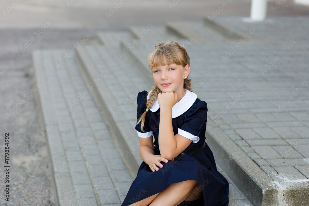 Portrait of a beautiful girl in a school uniform before class at school ...