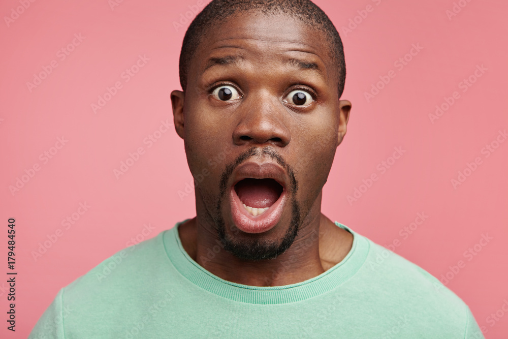 Indoor picture of scared bugged eyed African American male looks with ...
