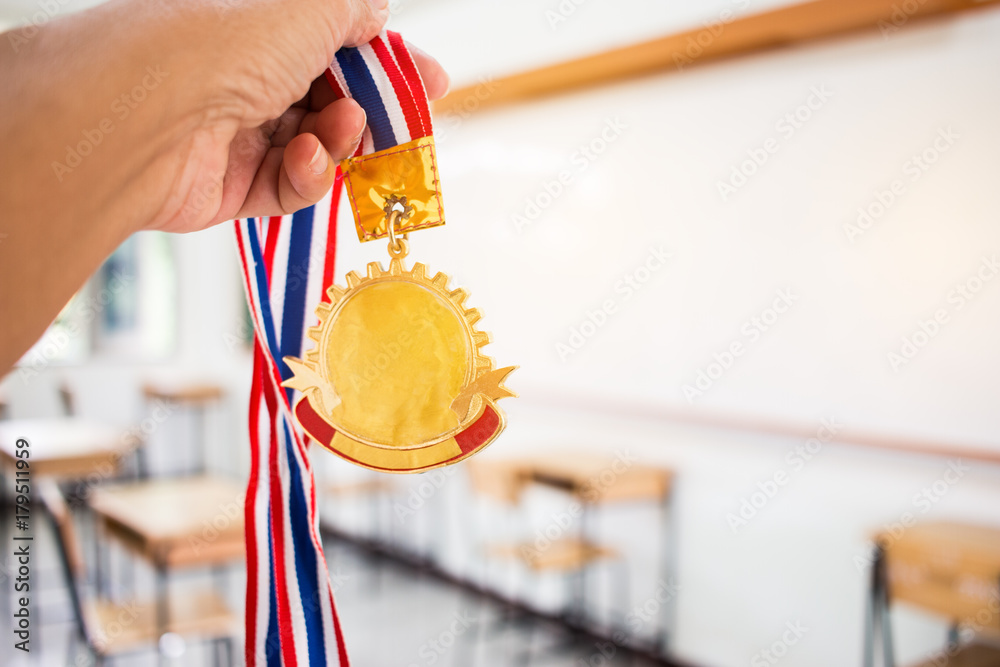 Students hands raised holding two gold medals with Thai ribbon against ...