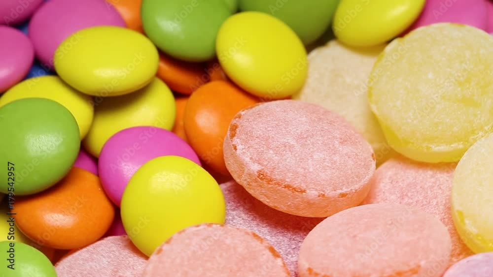 Macro video of many tasty round candies isolated on white background ...