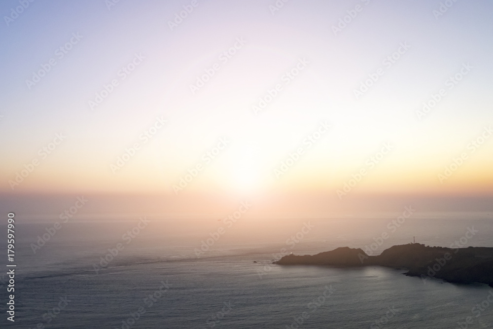 Glowing light of sunset shines across the horizon of the Pacific Ocean ...