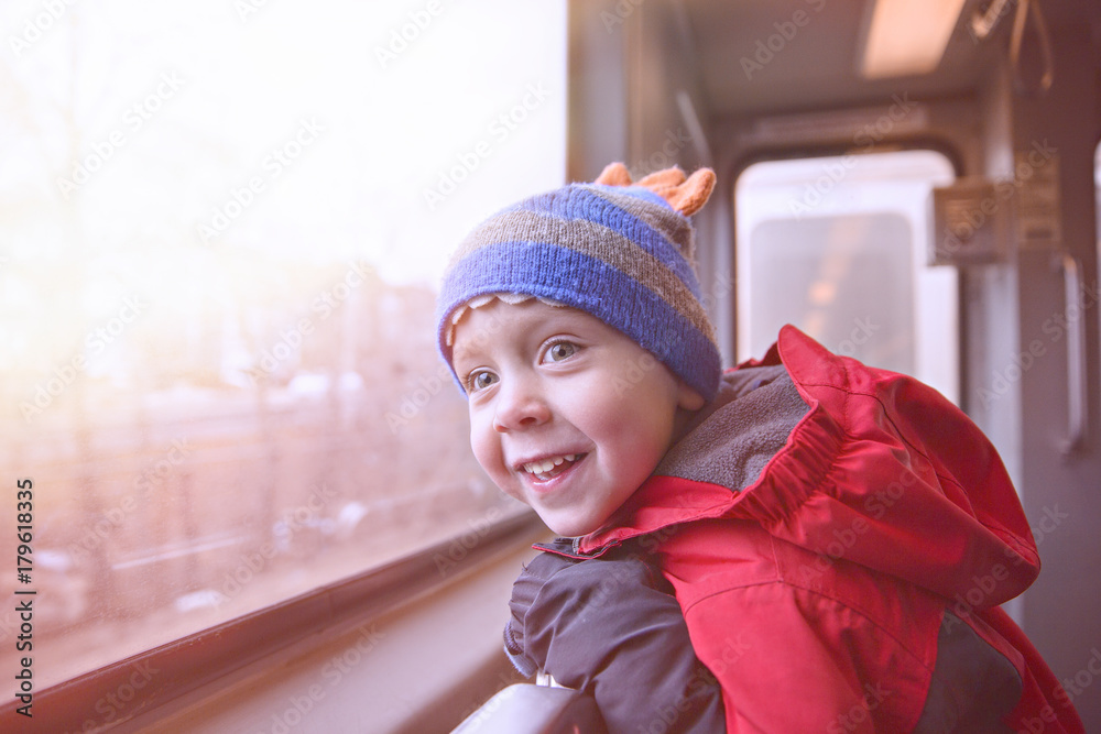 Joyful boy in the subway. child smiling looking out the window of a ...