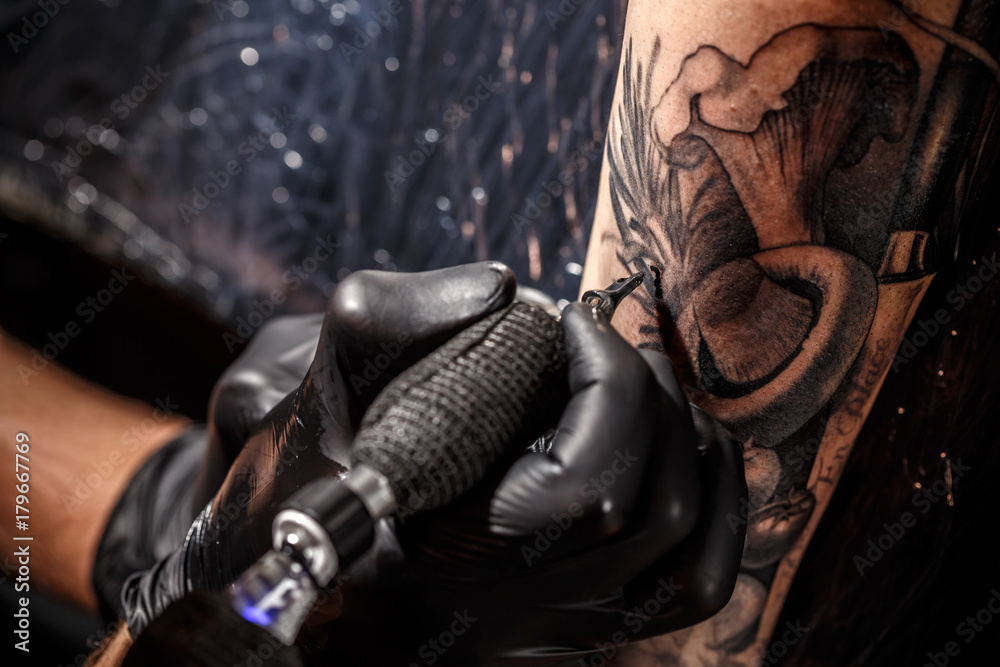 Tattoo artist makes a tattoo Stock Photo | Adobe Stock
