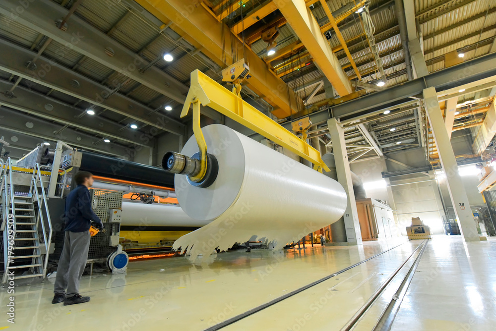 Papierrolle am Kran in einer Papierfabrik - Weiterverarbeitung von ...