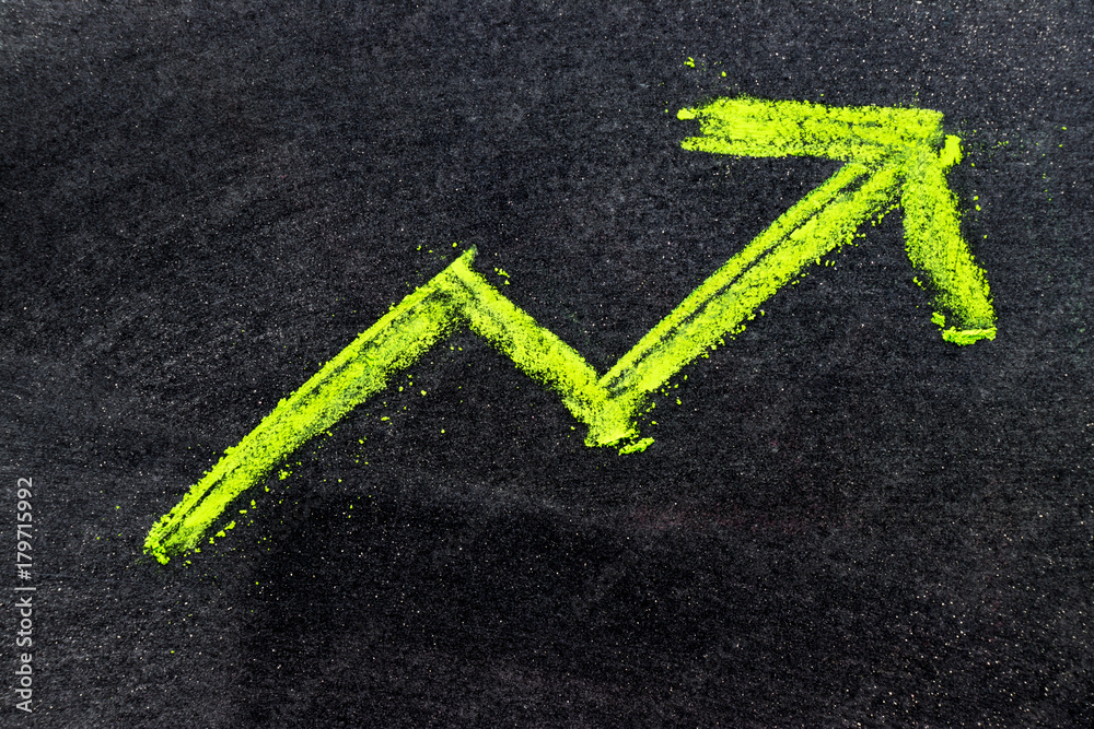Green color hand drawing chalk in arrow up shape on black board ...