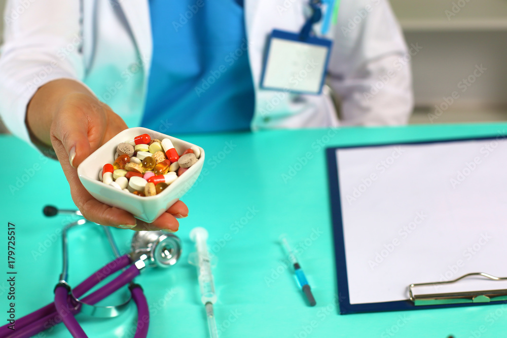Female doctor hand hold pack of different tablet blisters at workplace ...