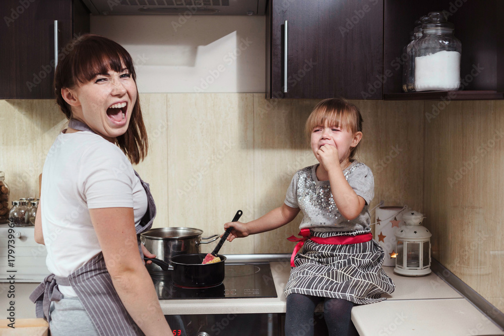 Little girl crying while cooking with her mother. Toddler throwing a ...