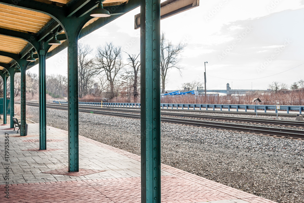 Empty above ground outdoor train station depot. Train tracks in gravel ...