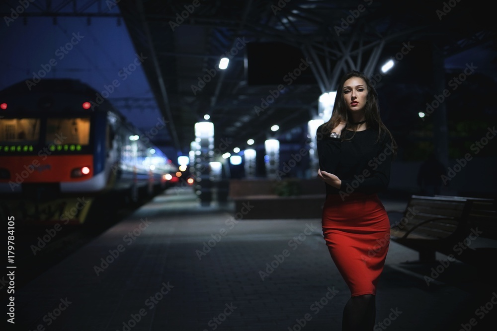 Beautiful young elegant woman traveler waiting for train at evening ...