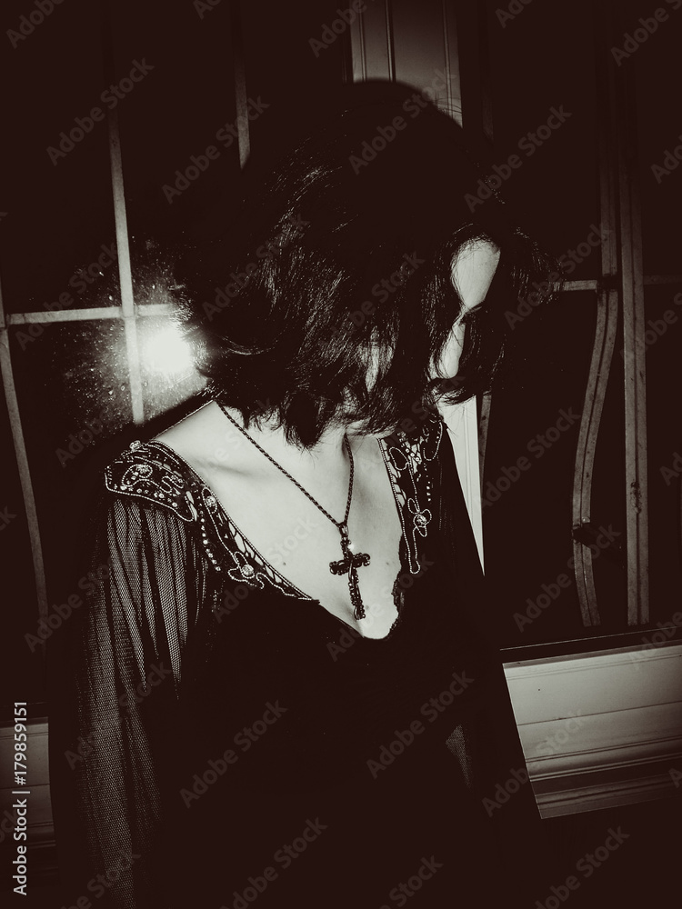 Portrait of lonely and sad goth girl in room. Passion for occultism and ...