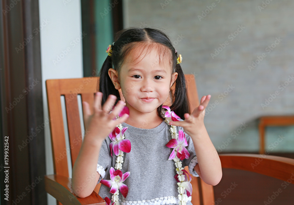 Cute smiling little Asian girl with welcome orchids flower garland ...