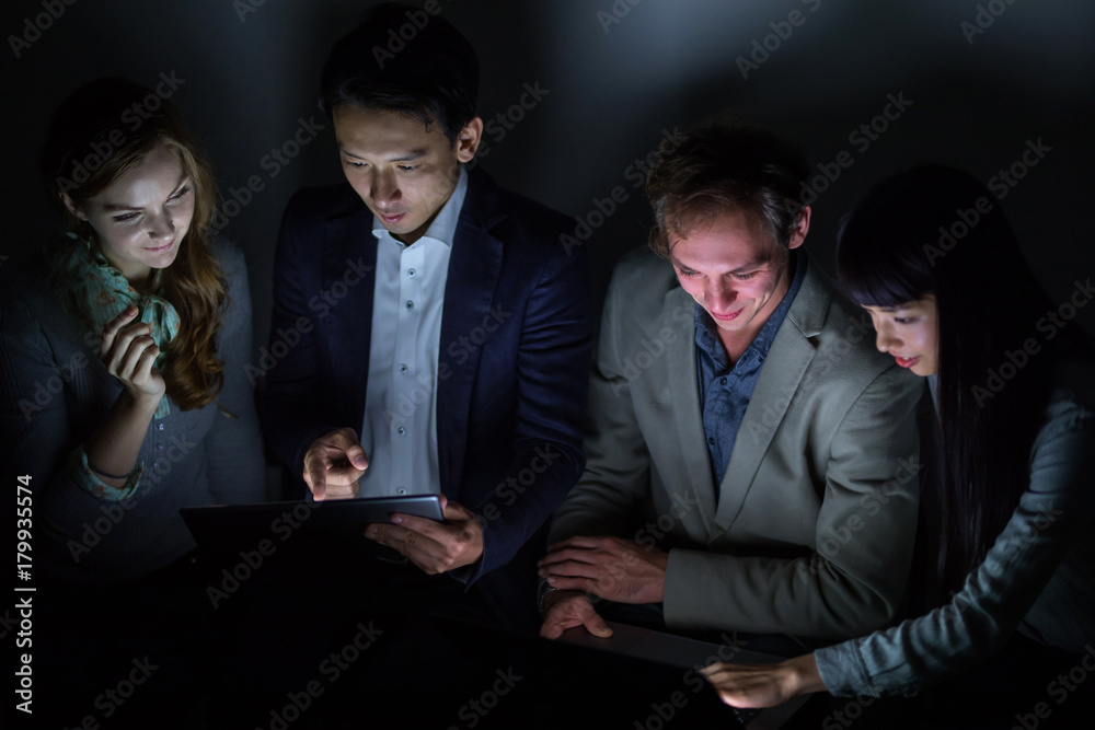 Group of people looking at screen in the dark. Stock Photo | Adobe Stock
