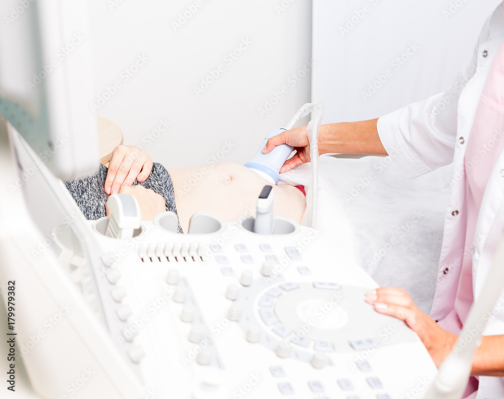 Doctor operating ultrasound machine performing obstetric ...