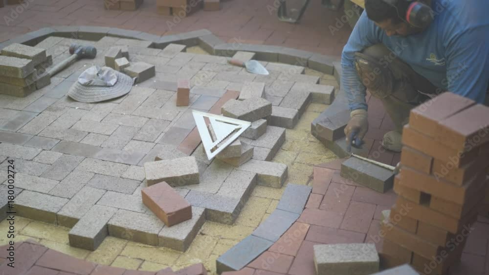 Man measures and marks a brick for cutting to fit into a custom ...